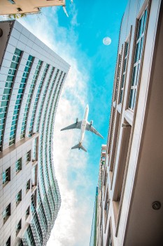 Wallpaper White Airplane Flying Over The High Rise Building During ...